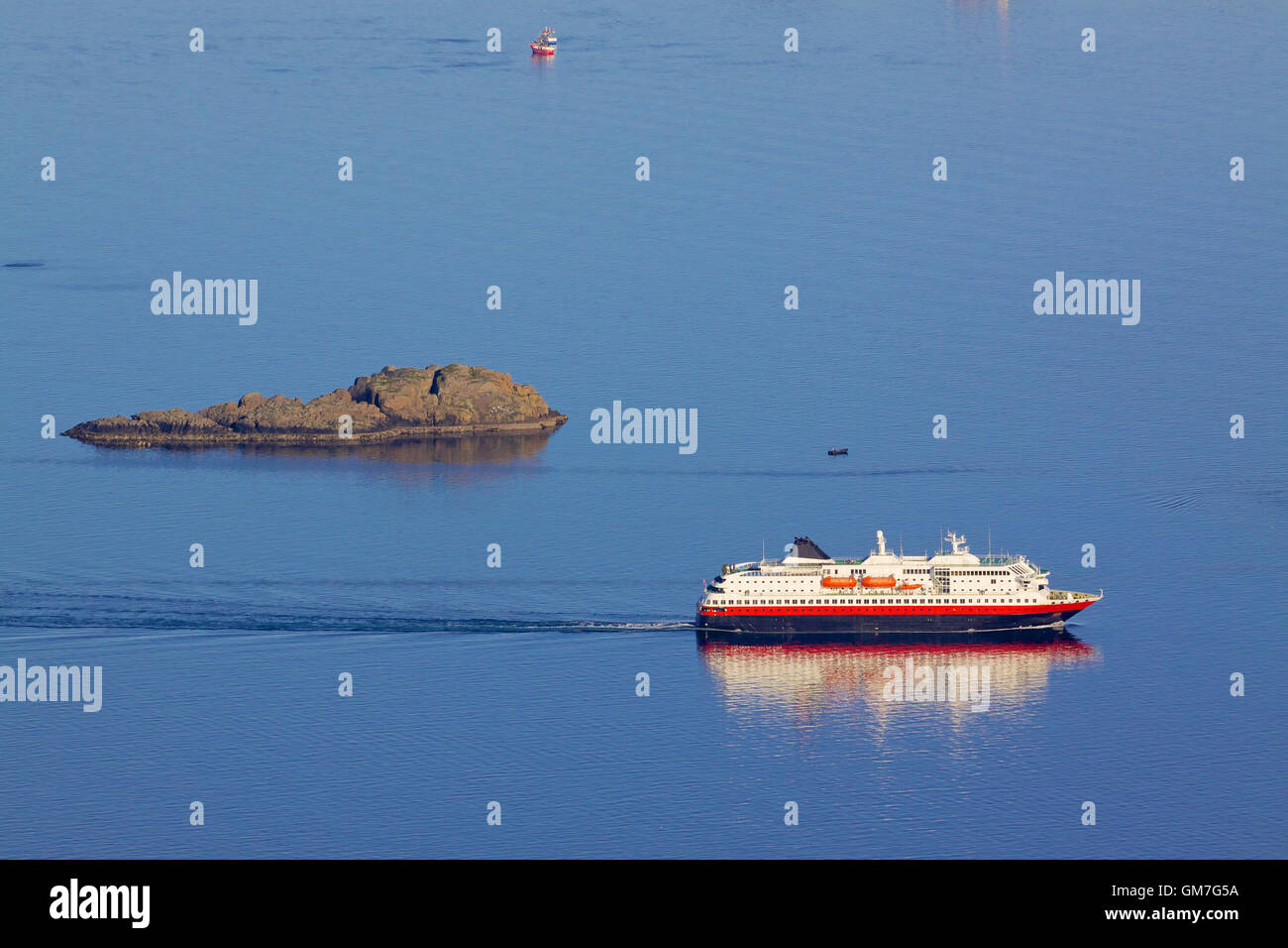 Cruising ship by rock island Stock Photo - Alamy