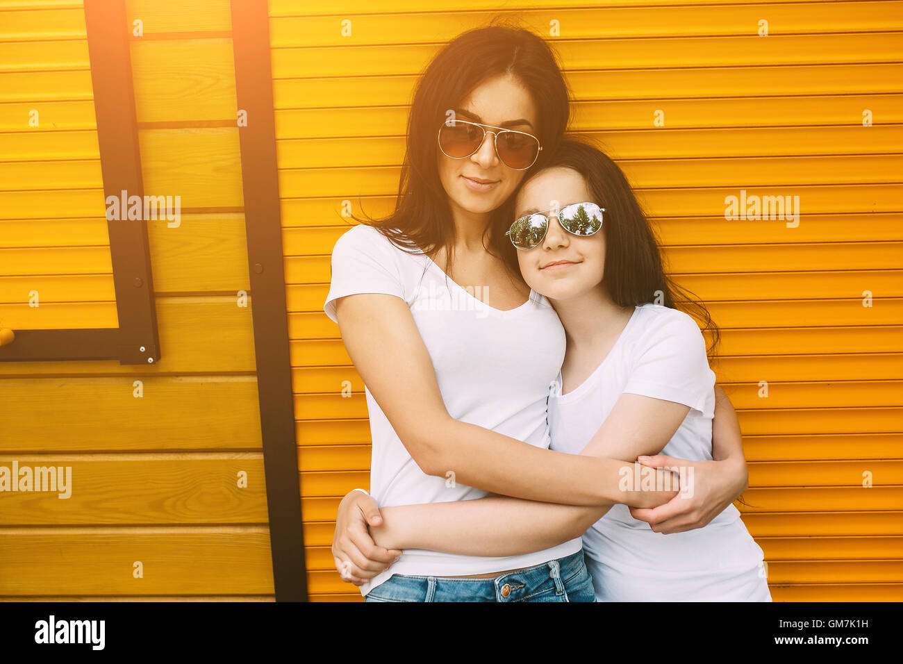mother and her cute daughter, against wall Stock Photo - Alamy