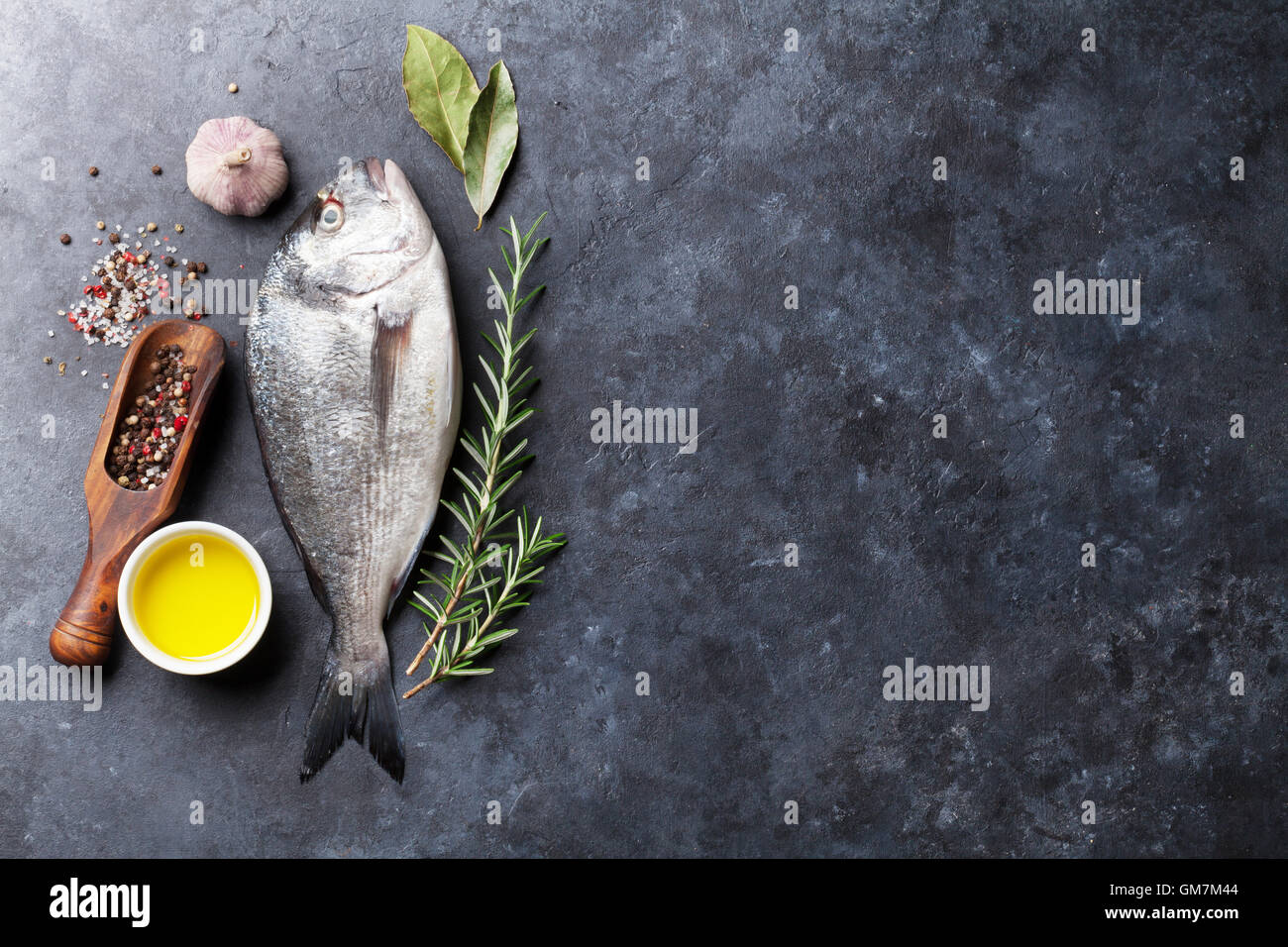 Raw fish cooking and ingredients. Dorado, herbs and spices. Top view ...