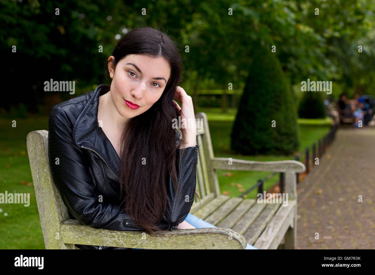 Young woman sitting on a park park Stock Photo - Alamy