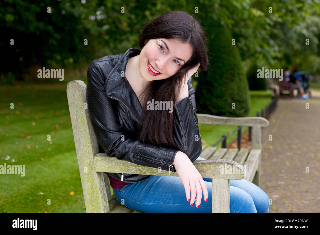 Happy girl sitting in the park Stock Photo - Alamy