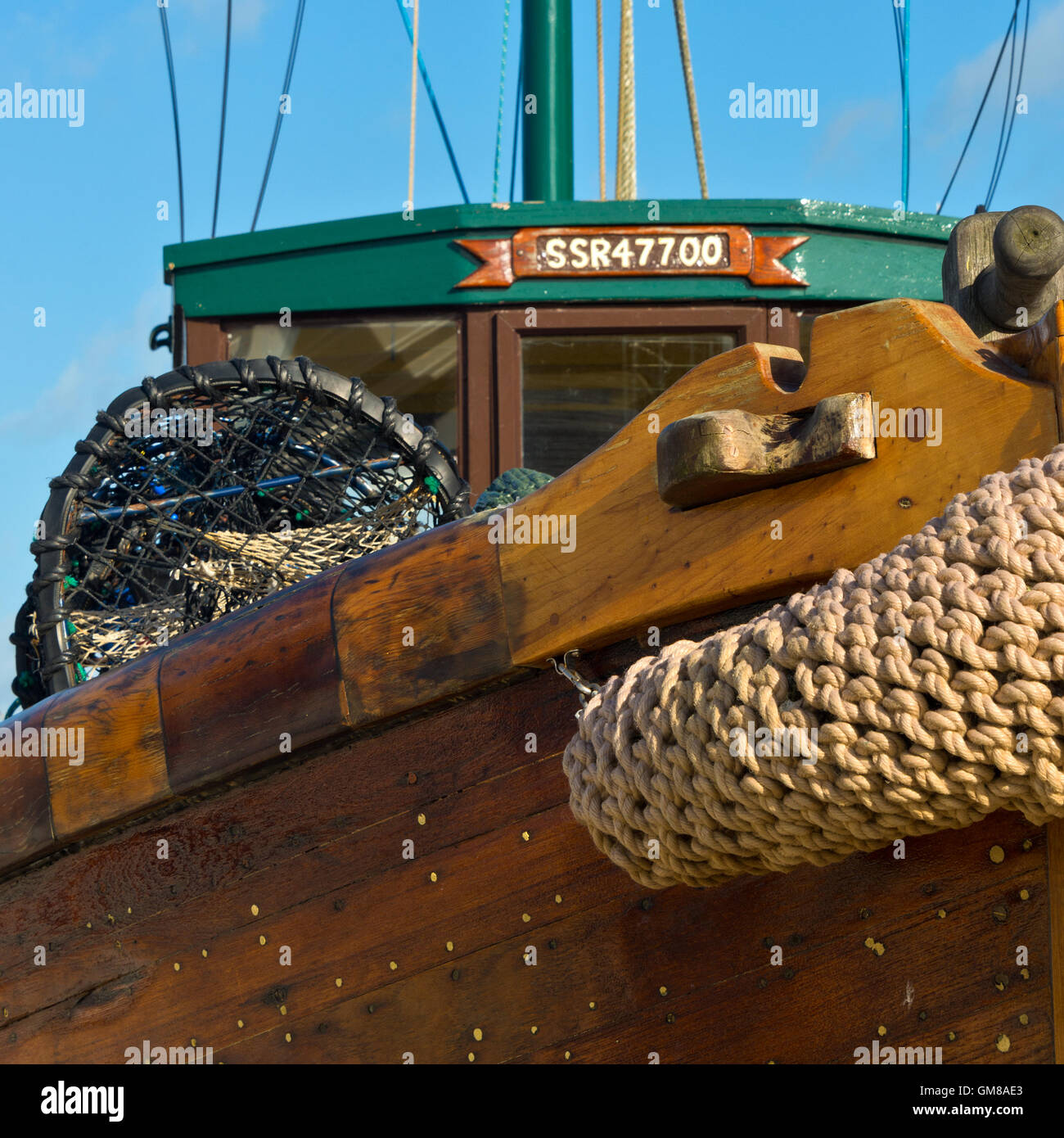 Wooden fishing boat laden with fishing pots at West Bay on the jurassic ...