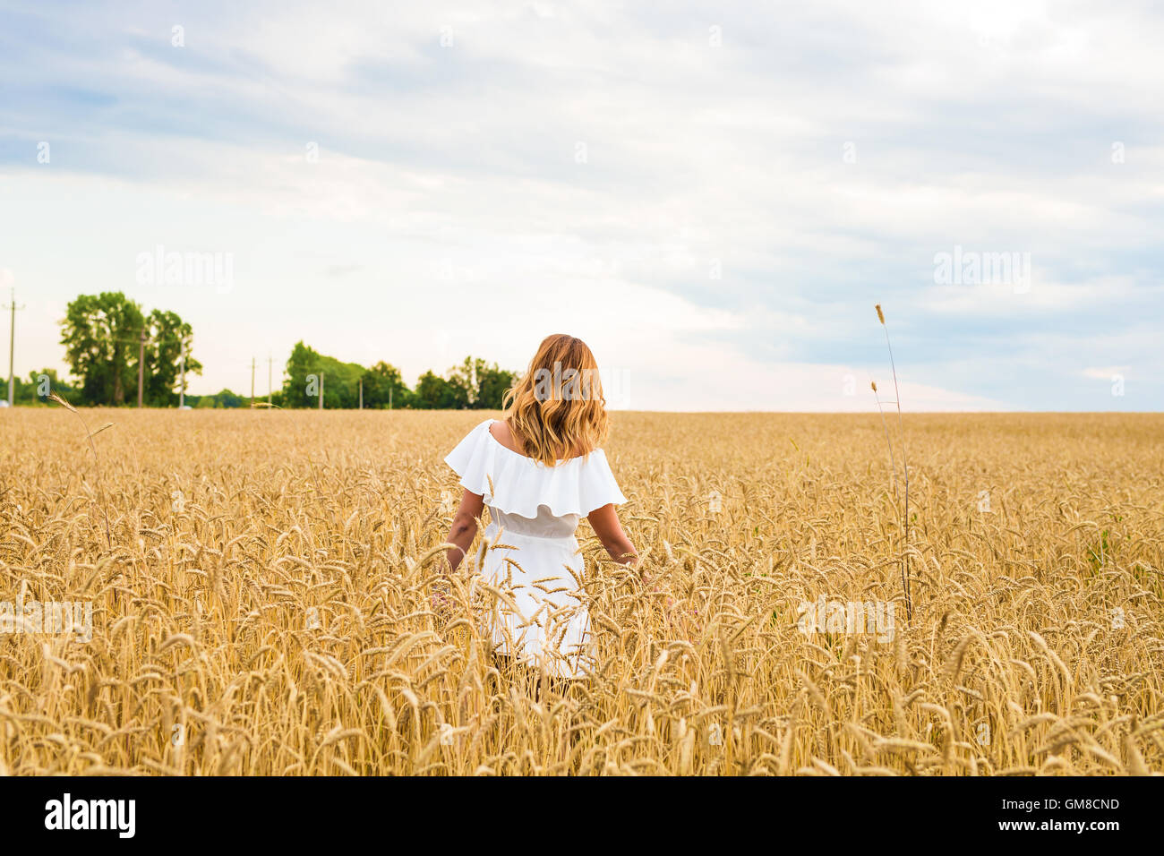 Young woman walking in the field Stock Photo - Alamy
