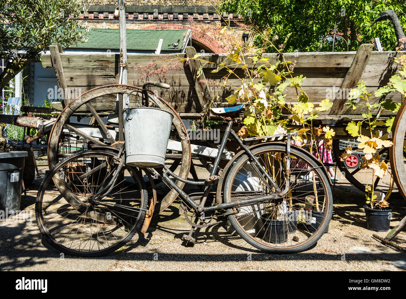 An old rusting bicycle and saddle surrounded by farm implements and ...