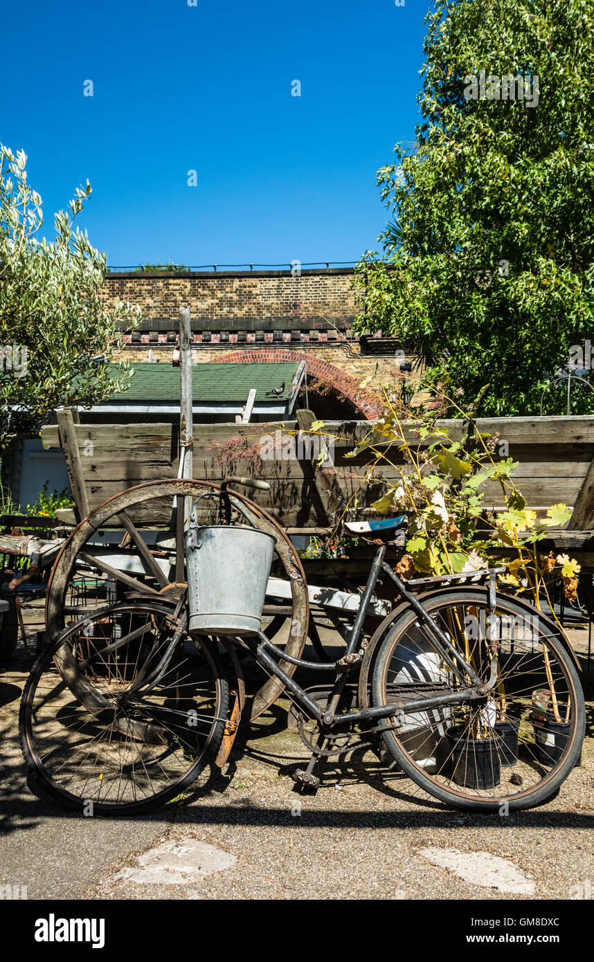An old rusting bicycle and saddle surrounded by farm implements and ...