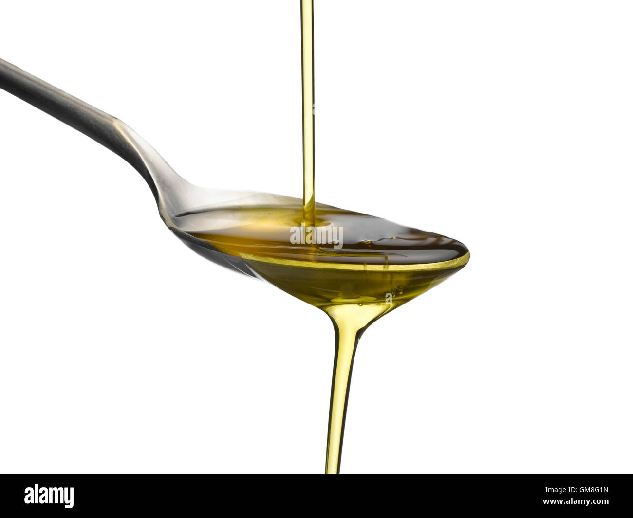cooking oil pouring onto a spoon isolated on a white background Stock ...