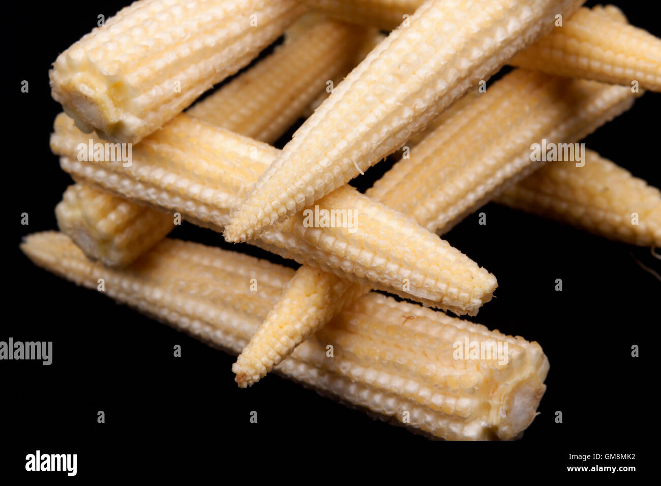 Baby corn on black background Stock Photo - Alamy