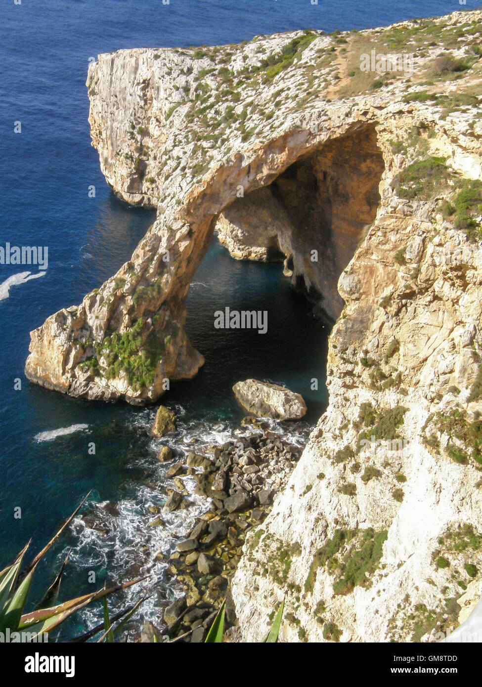 A natural stone arch reaches into the sea Stock Photo - Alamy