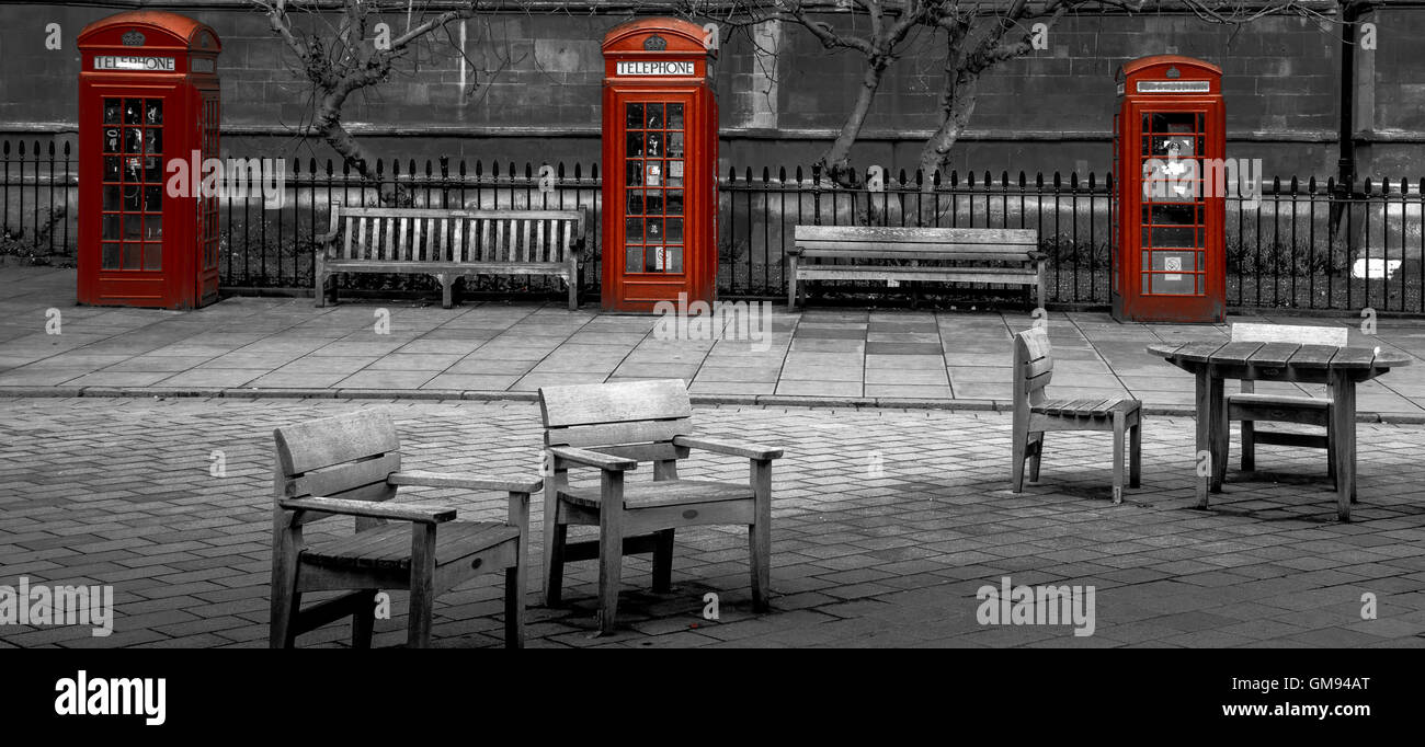 Three red phone boxes in public park space Stock Photo - Alamy