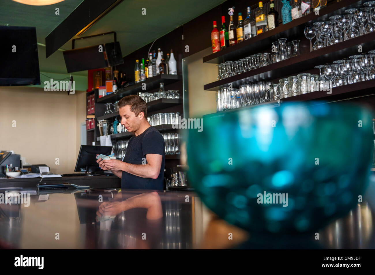 Man behind counter of a cafe counting money Stock Photo - Alamy