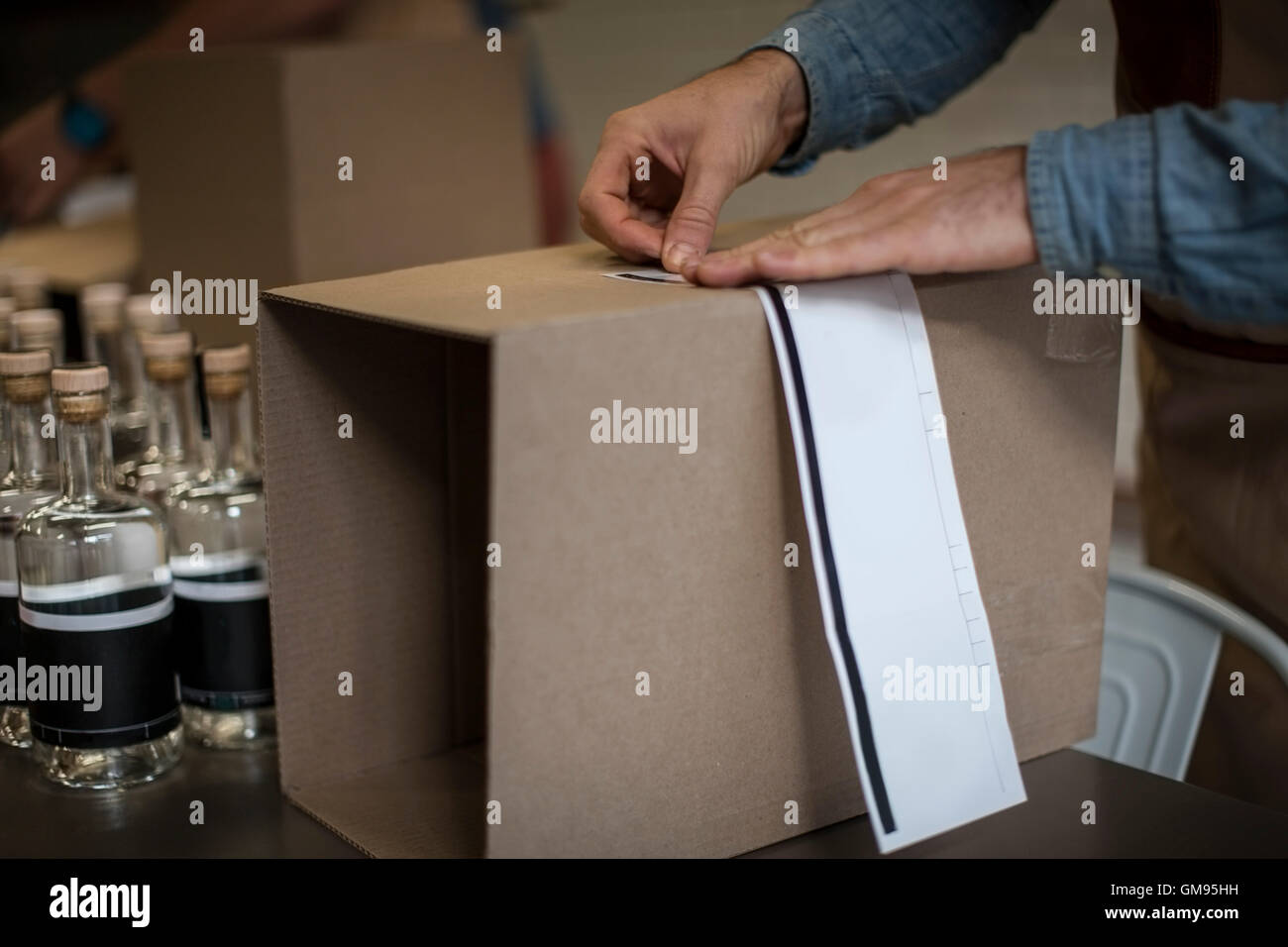 Man adding note tape to box Stock Photo - Alamy