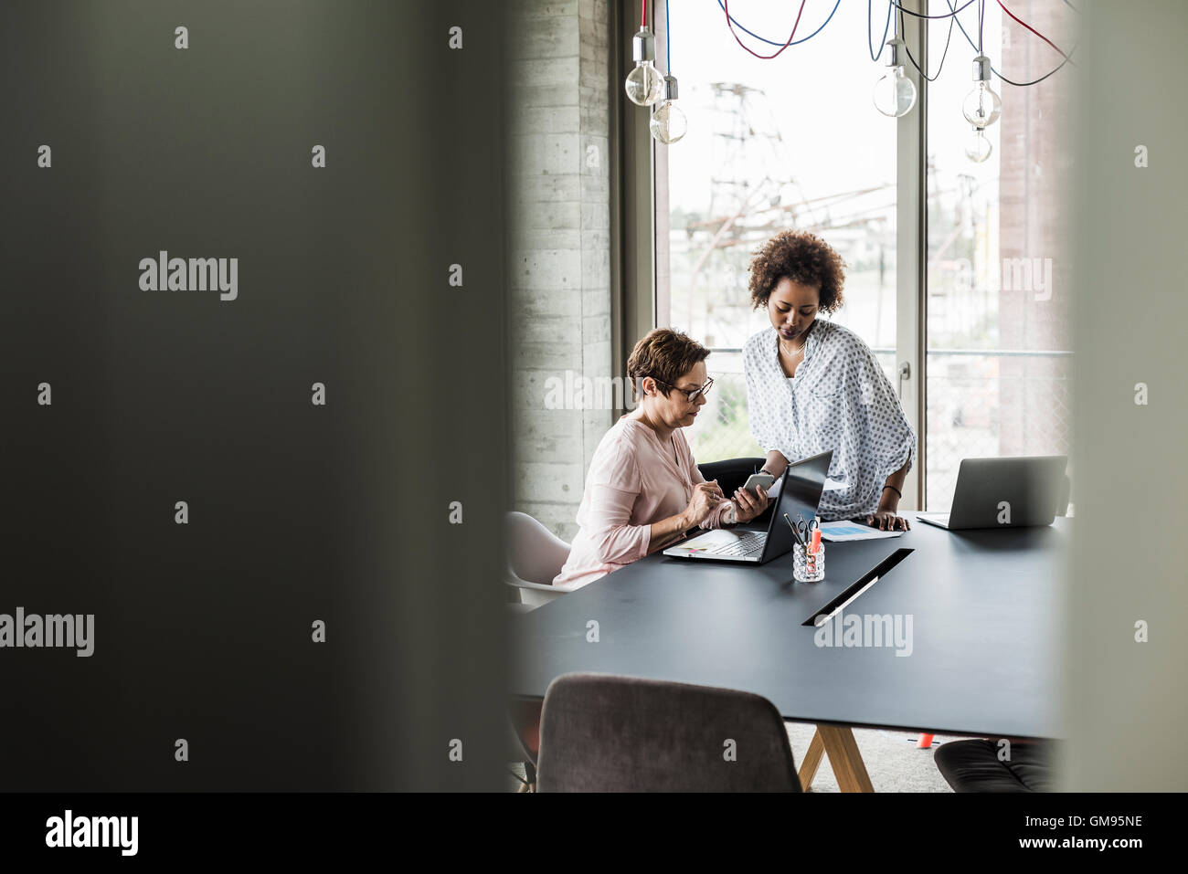 Two women working together in an office Stock Photo - Alamy