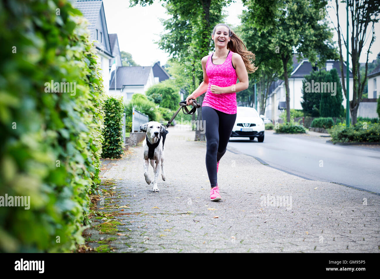 Young woman jogging with dog Stock Photo - Alamy
