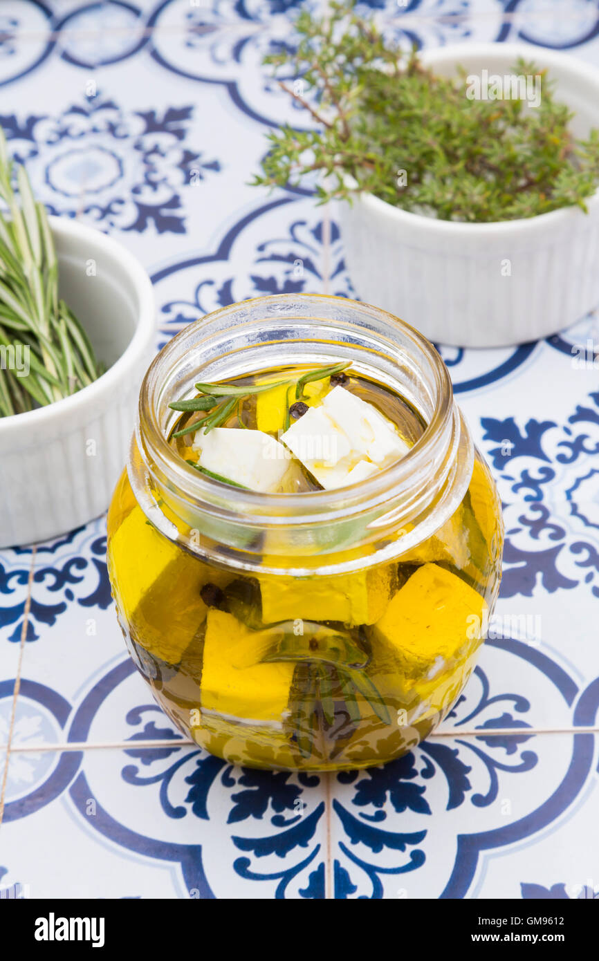 Glass of diced sheep cheese pickled in olive oil, thyme, garlic, pepper ...