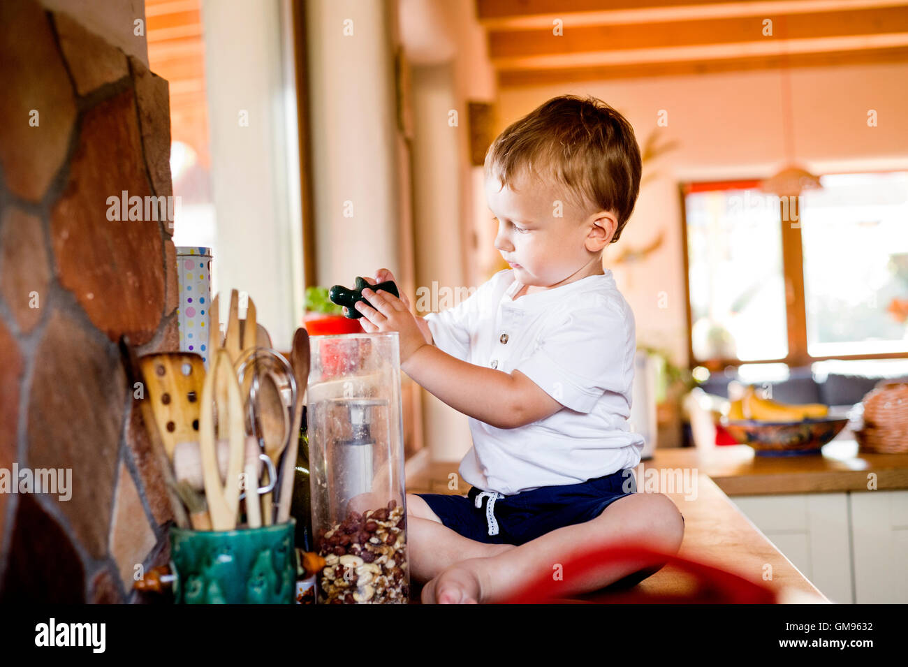 Little boy is playing in kitchen Stock Photo - Alamy