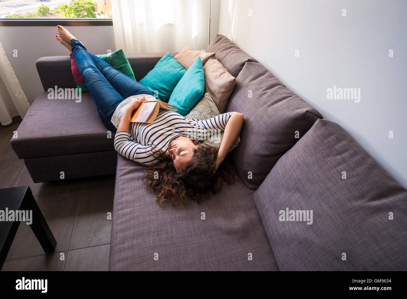 Woman relaxing on couch Stock Photo - Alamy