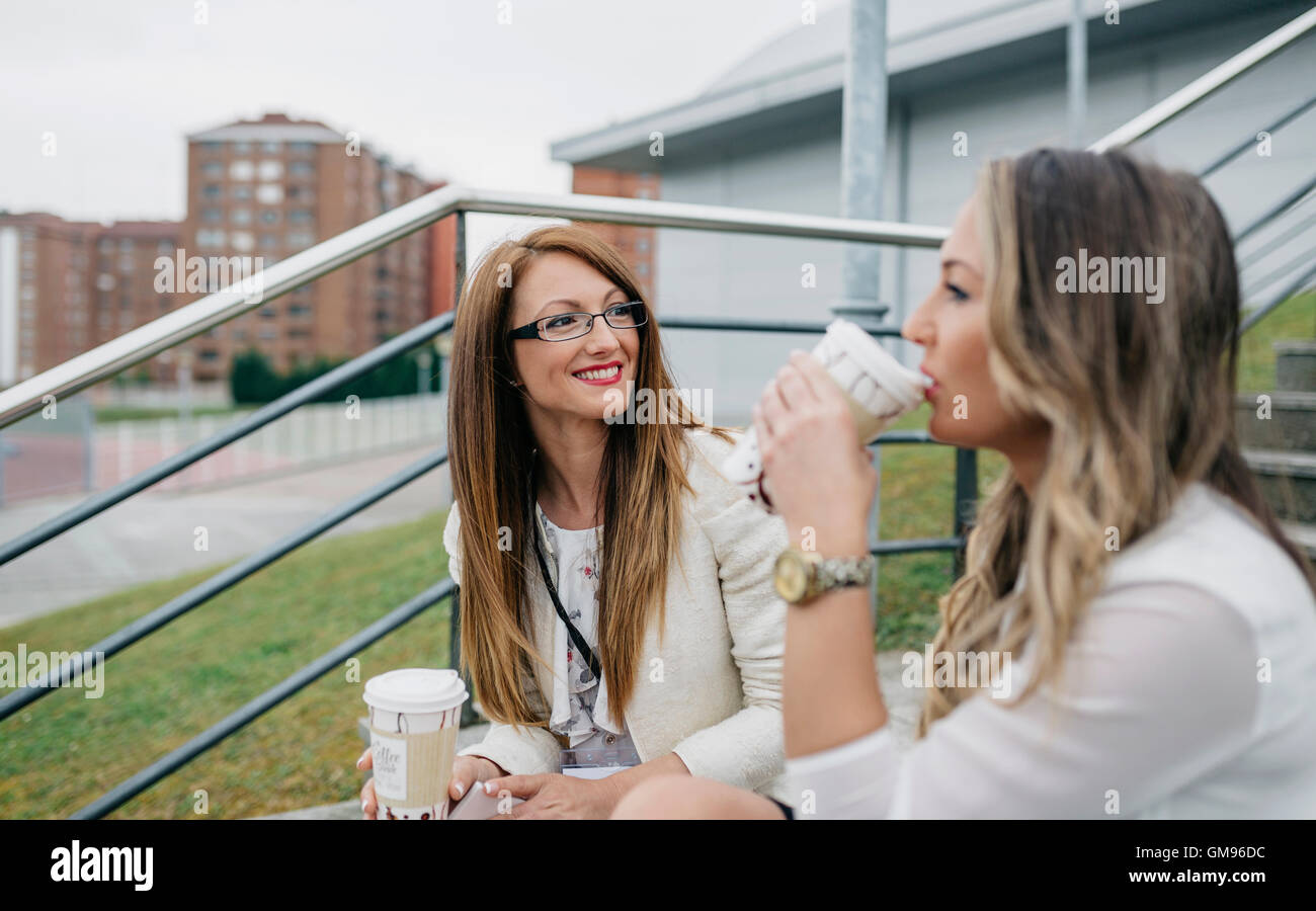 Two women having coffee break outdoors Stock Photo - Alamy