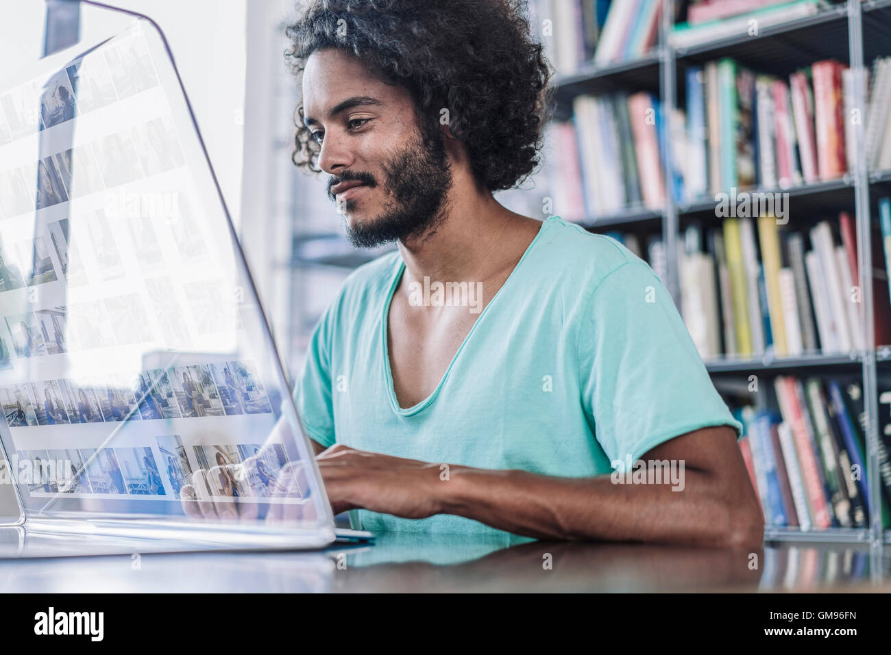 Young man working in library, using futuristic computer Stock Photo - Alamy
