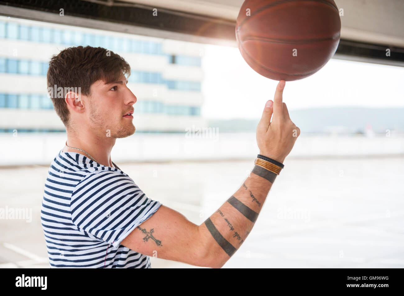Young man balancing basketball on finger Stock Photo - Alamy