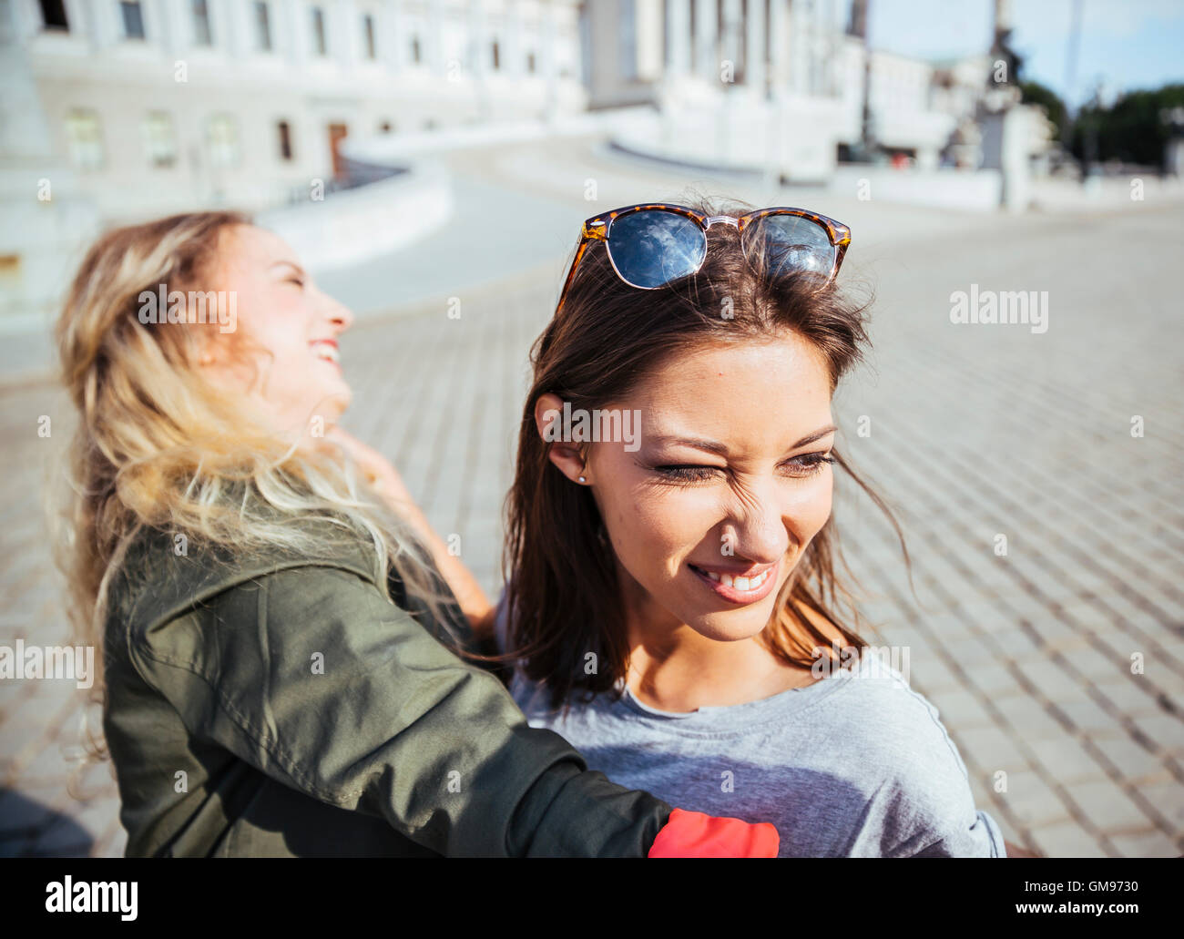 Austria, Vienna, two young women having fun in front of the parliament ...