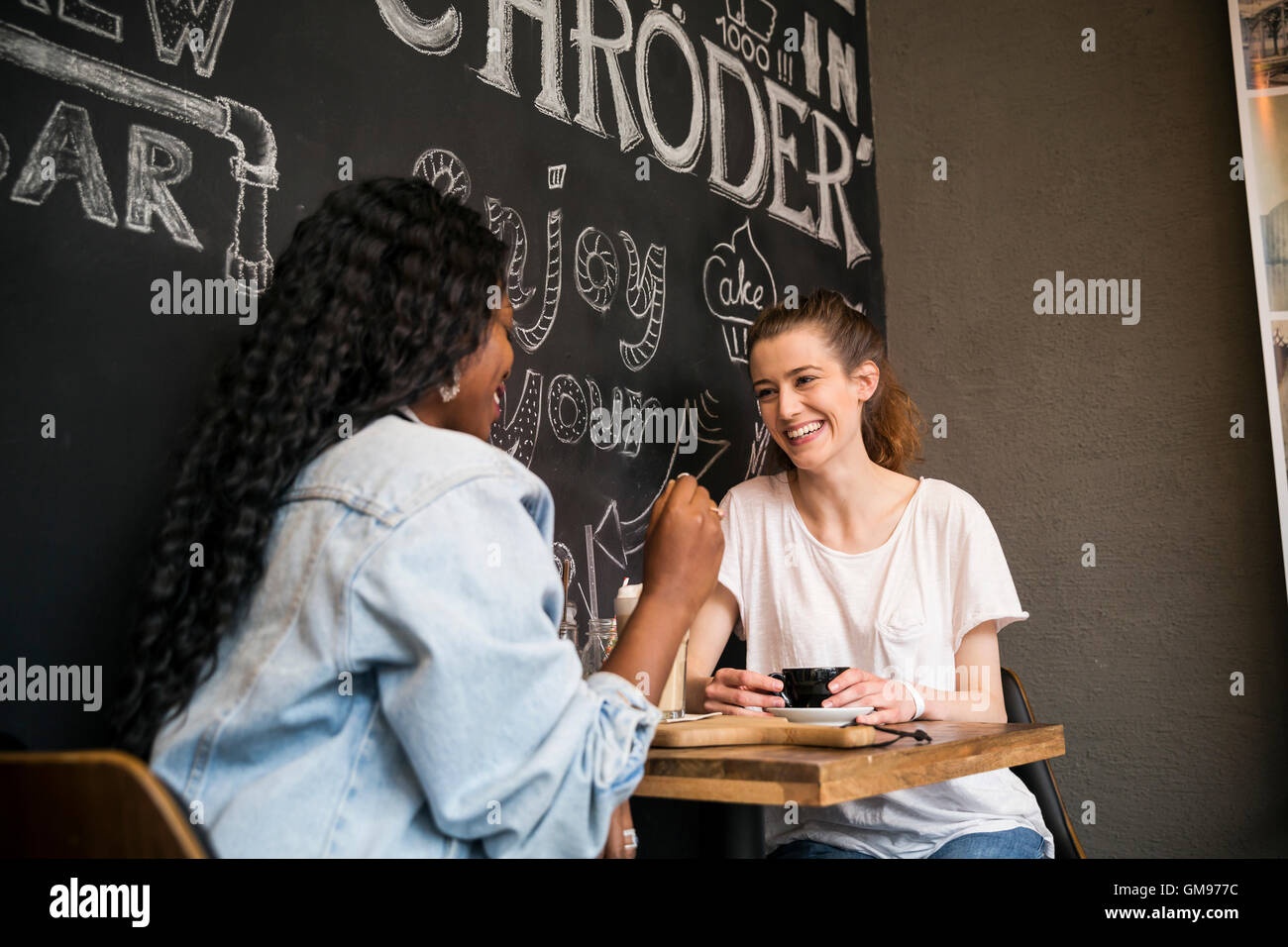 Two friends meeting in cafe, chatting Stock Photo - Alamy