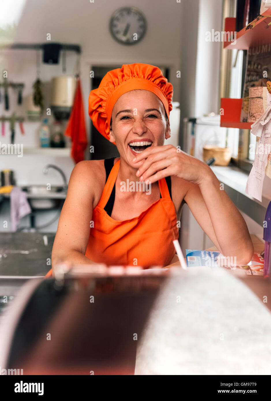 Portrait of laughing cook wearing orange chef's hat and apron Stock ...