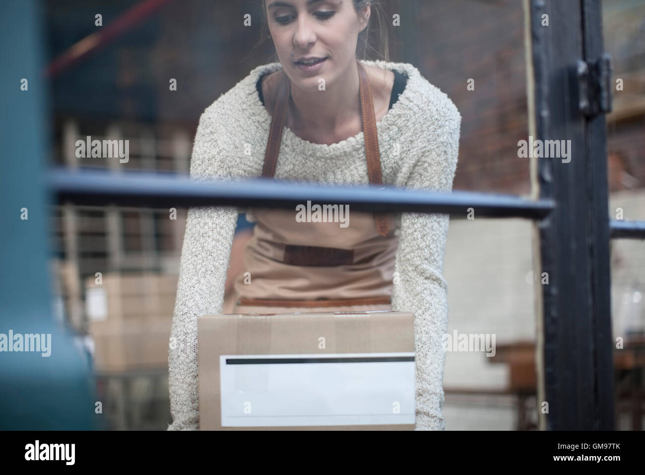 Young woman picking up cardboard box Stock Photo - Alamy