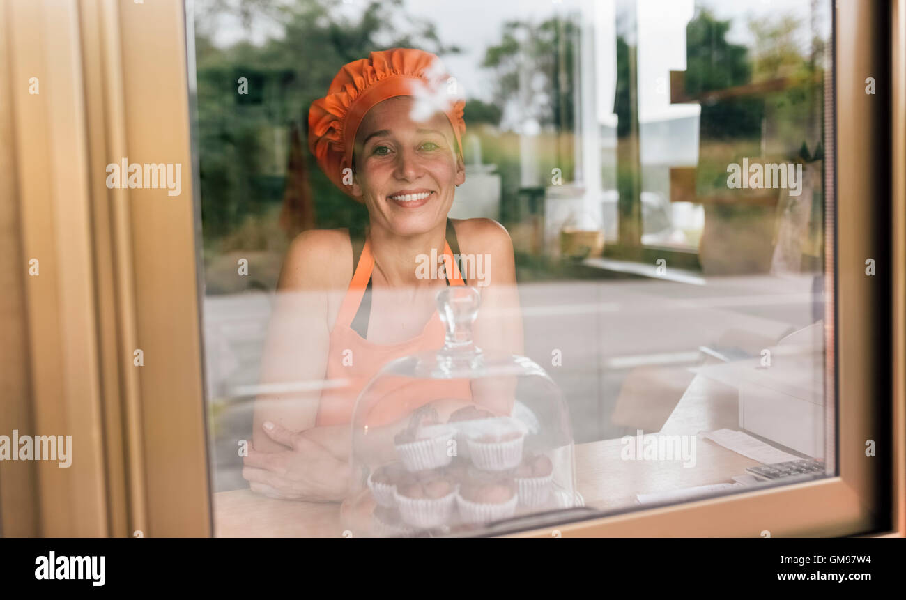 Portrait of smiling cook behind window pane Stock Photo - Alamy