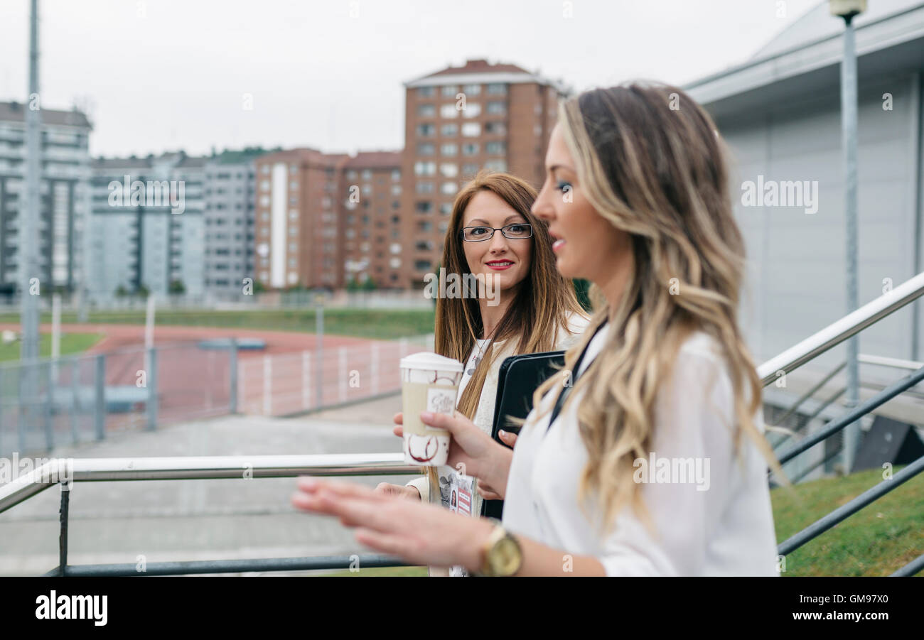 Two women having coffee break outdoors Stock Photo - Alamy