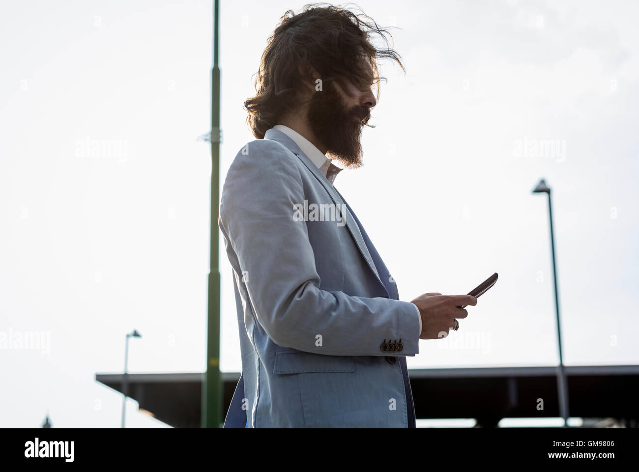 Stylish businessman using cell phone outdoors Stock Photo - Alamy