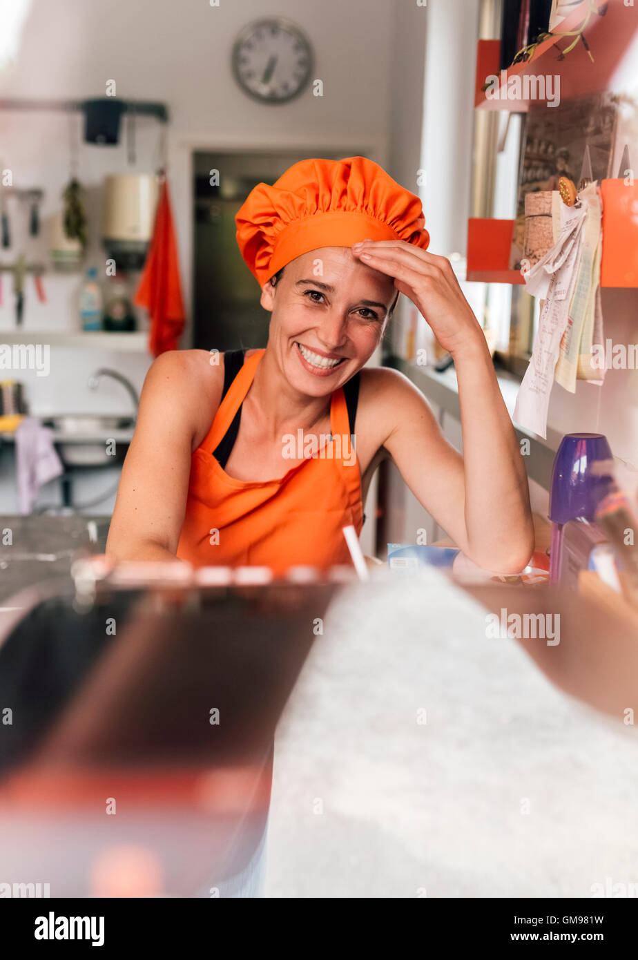 Portrait of laughing cook wearing orange chef's hat and apron Stock ...