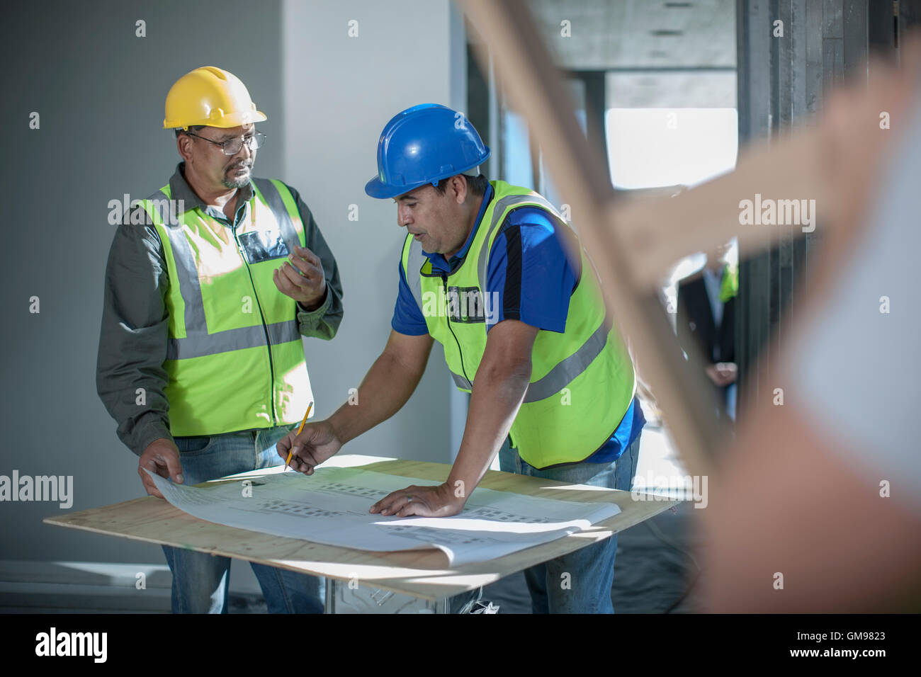 Two construction workers talking Stock Photo - Alamy