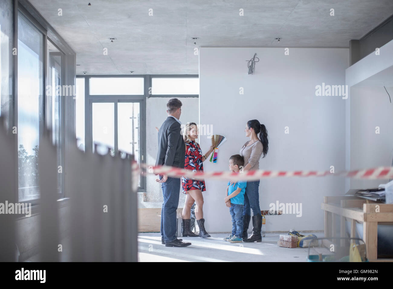 Woman with color sample and family in building shell Stock Photo - Alamy