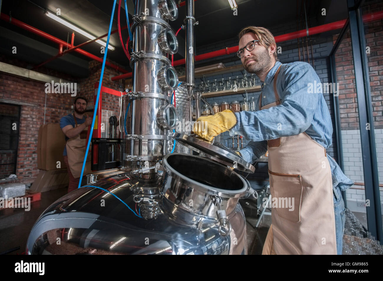 Man working at machine in distillery Stock Photo - Alamy
