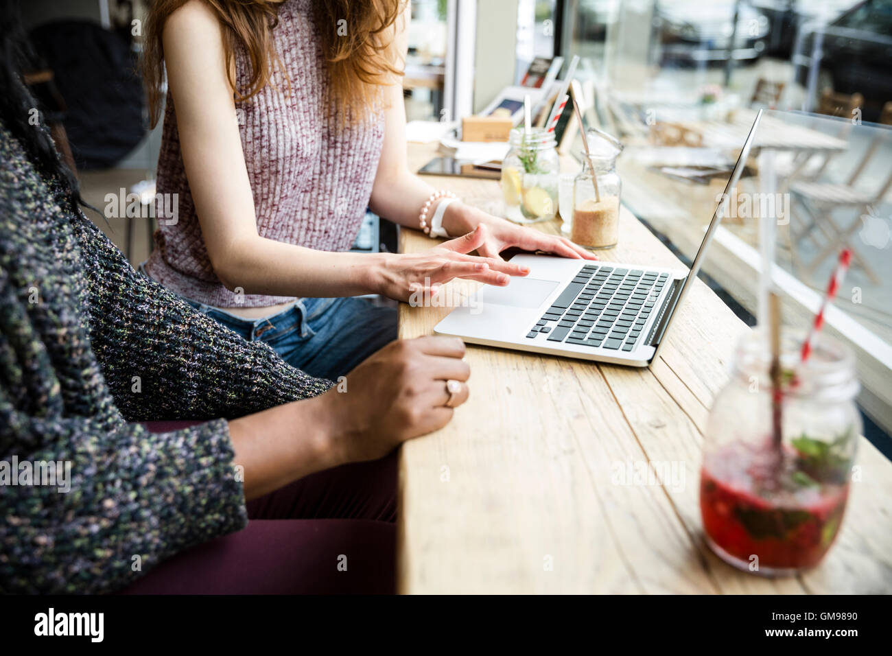 Two friends having a meeting cafe, using laptop Stock Photo - Alamy