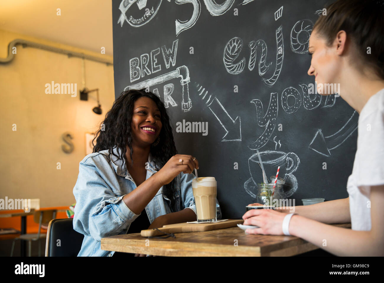 Two friends meeting in cafe, chatting Stock Photo - Alamy