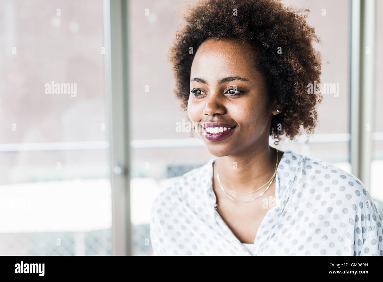 Portrait of smiling businesswoman looking through window Stock Photo ...