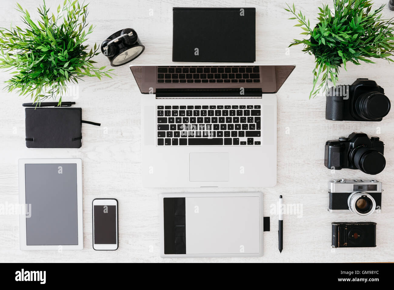 Desk of photographer with laptop, cameras, tablet and graphics tablet ...