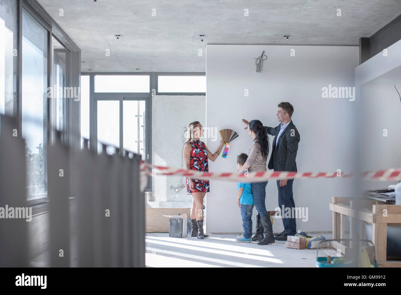 Woman with color sample and family in building shell Stock Photo - Alamy