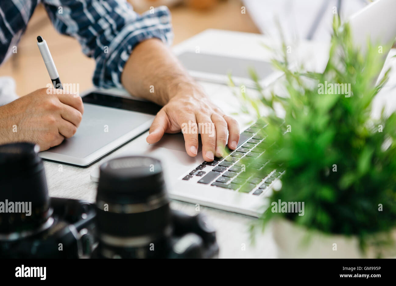 Photographer working at desk with graphics tablet, partial view Stock ...