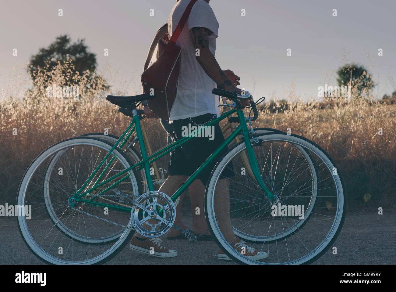 Two men walking with vintage bicycles in rural landscape Stock Photo ...