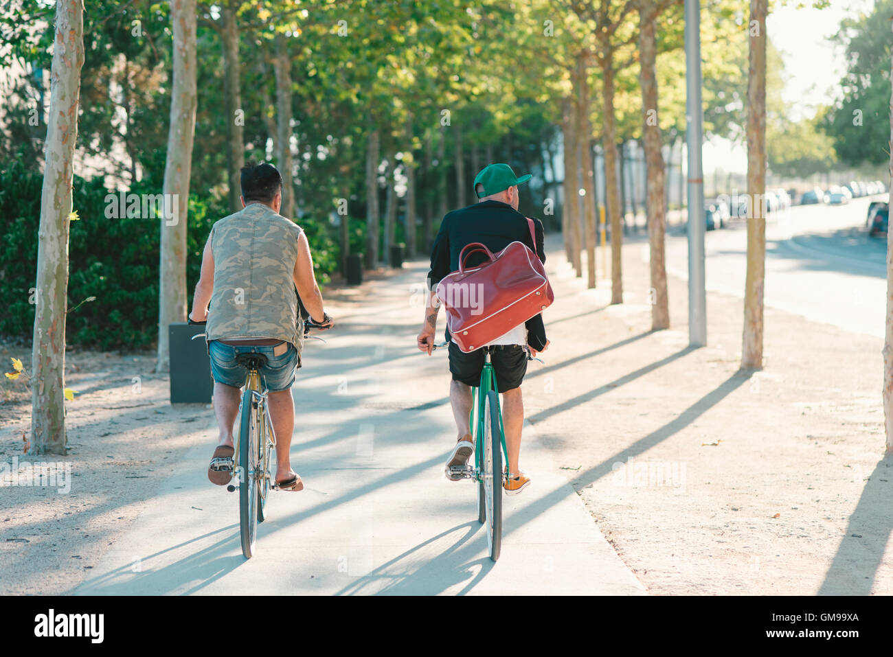 Two men riding bike Stock Photo - Alamy