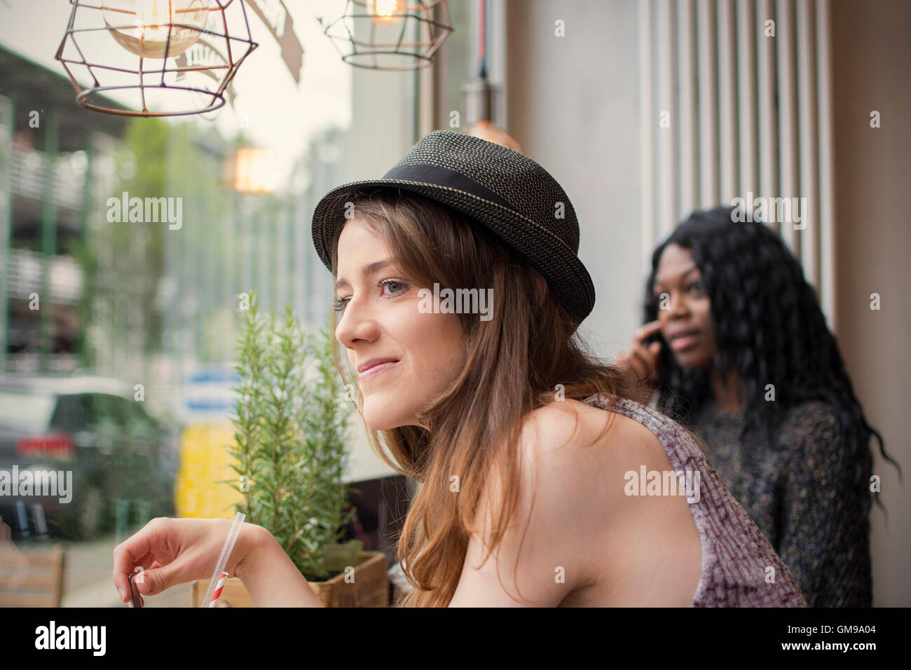 Friend sitting in a cafe, looking out of window Stock Photo - Alamy