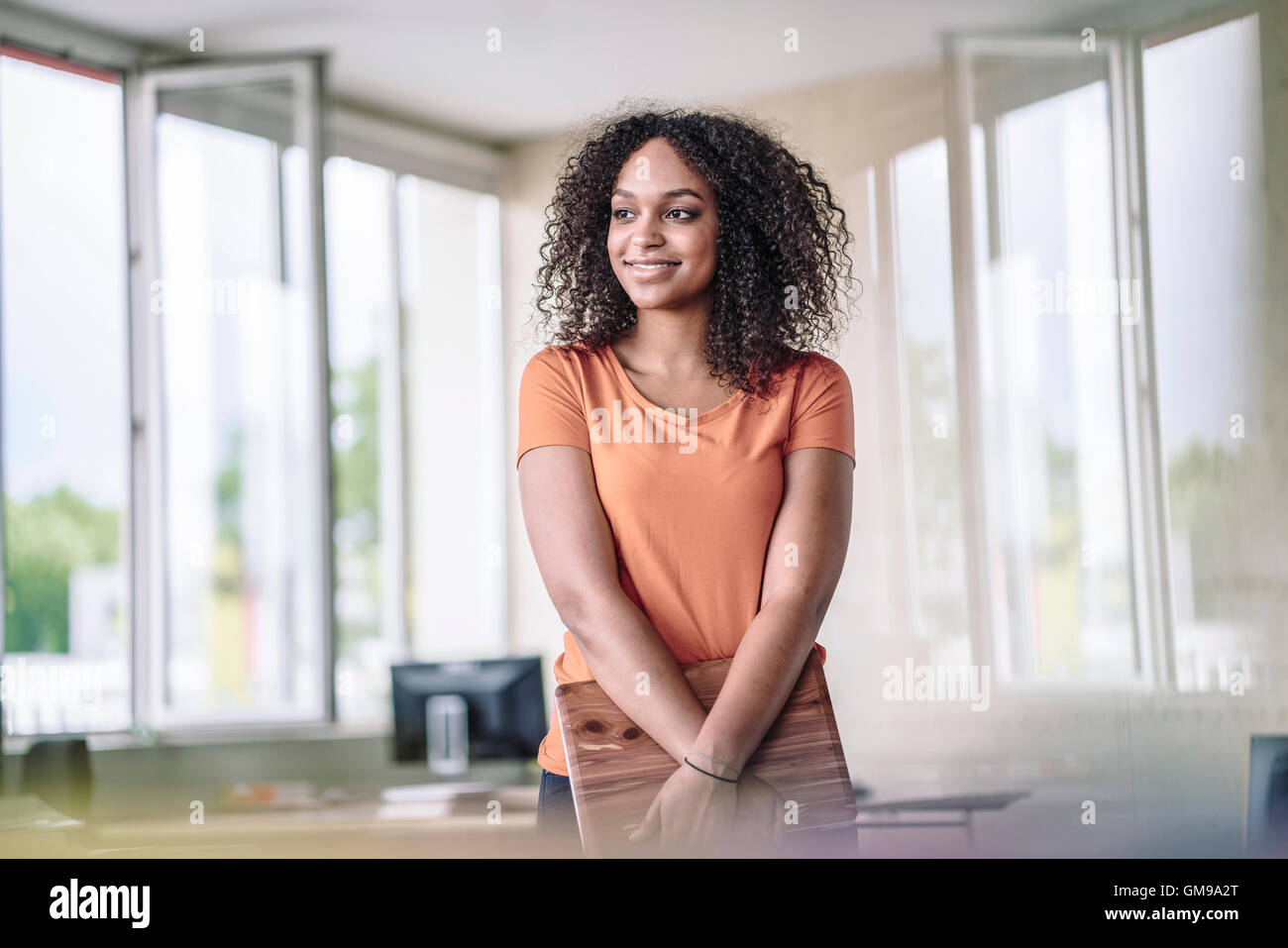Young woman in office carrying laptop Stock Photo - Alamy