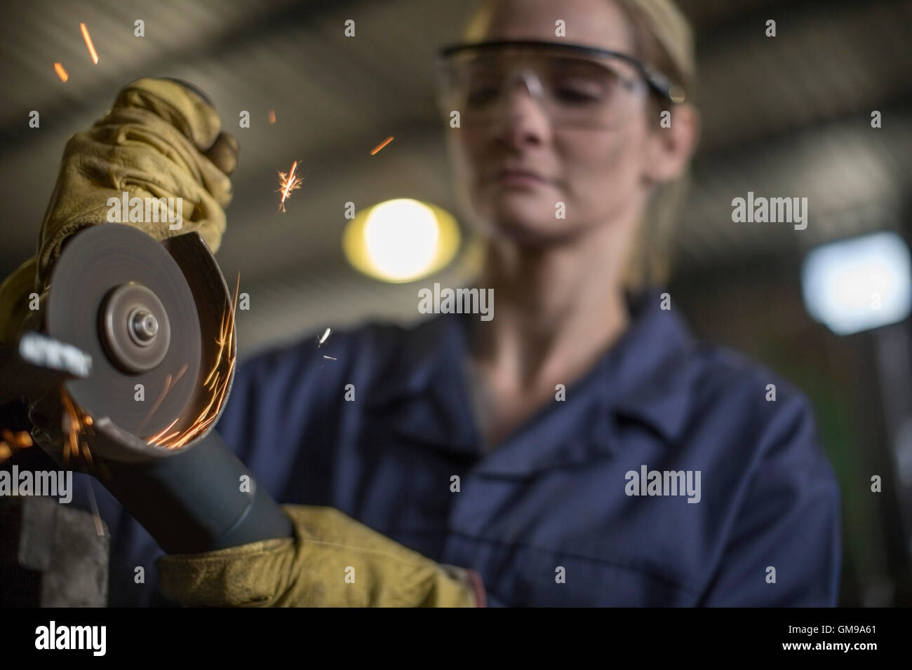 Female mechanic using grinding machine in workshop Stock Photo - Alamy