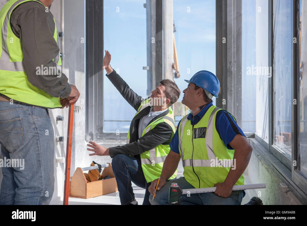 Architect and construction workers on construction site Stock Photo - Alamy
