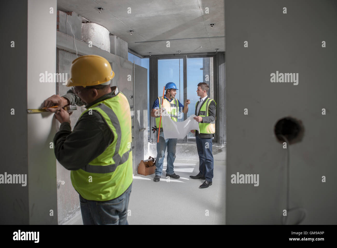 Architect and construction workers on construction site Stock Photo - Alamy