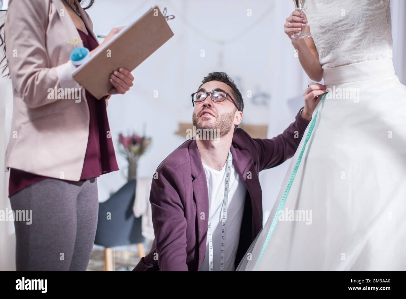 Taking measurements for client in fashion showroom Stock Photo - Alamy