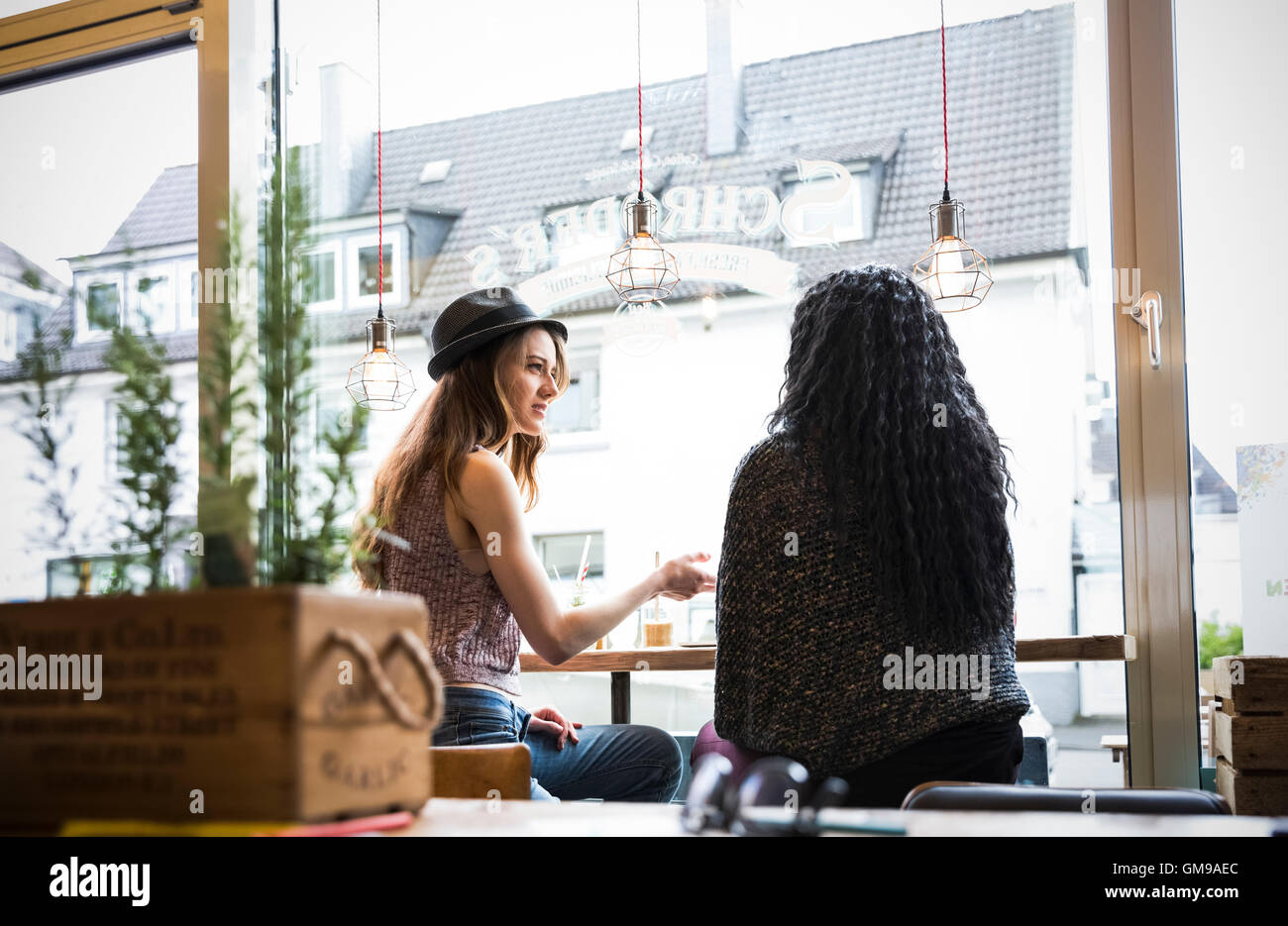 Two friends sitting in cafe, talking Stock Photo - Alamy