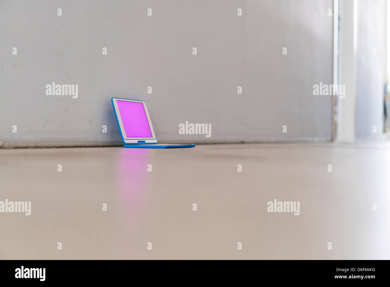 Digital tablet with pink screen on floor of office Stock Photo - Alamy